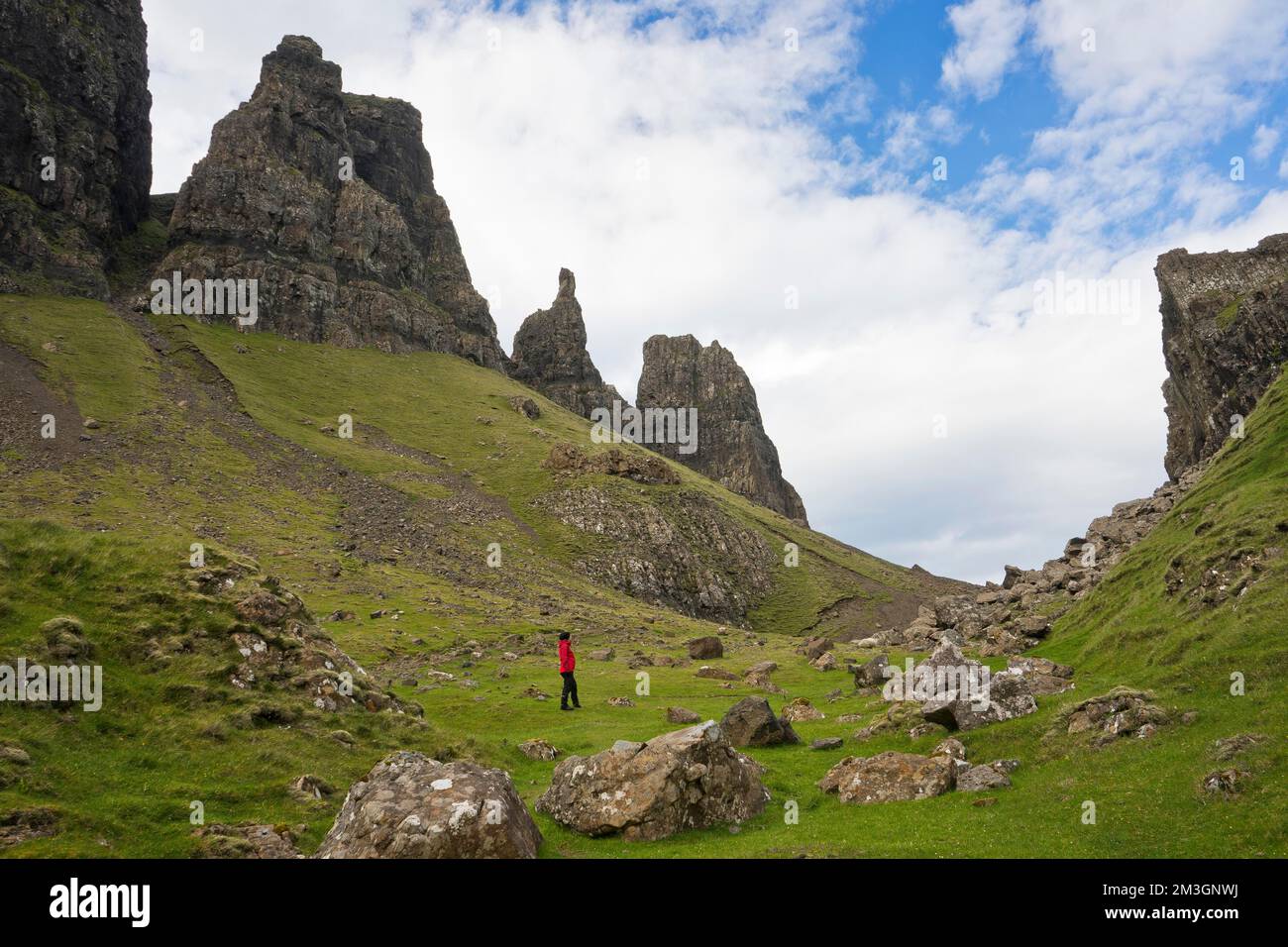 Hiker in red outdoor jacket in the bizarre rock world of Quiraing ...