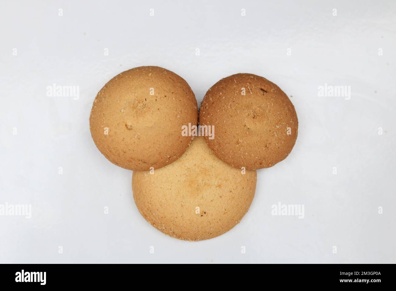 A row of three ginger biscuits,round cookies isolated on white ...