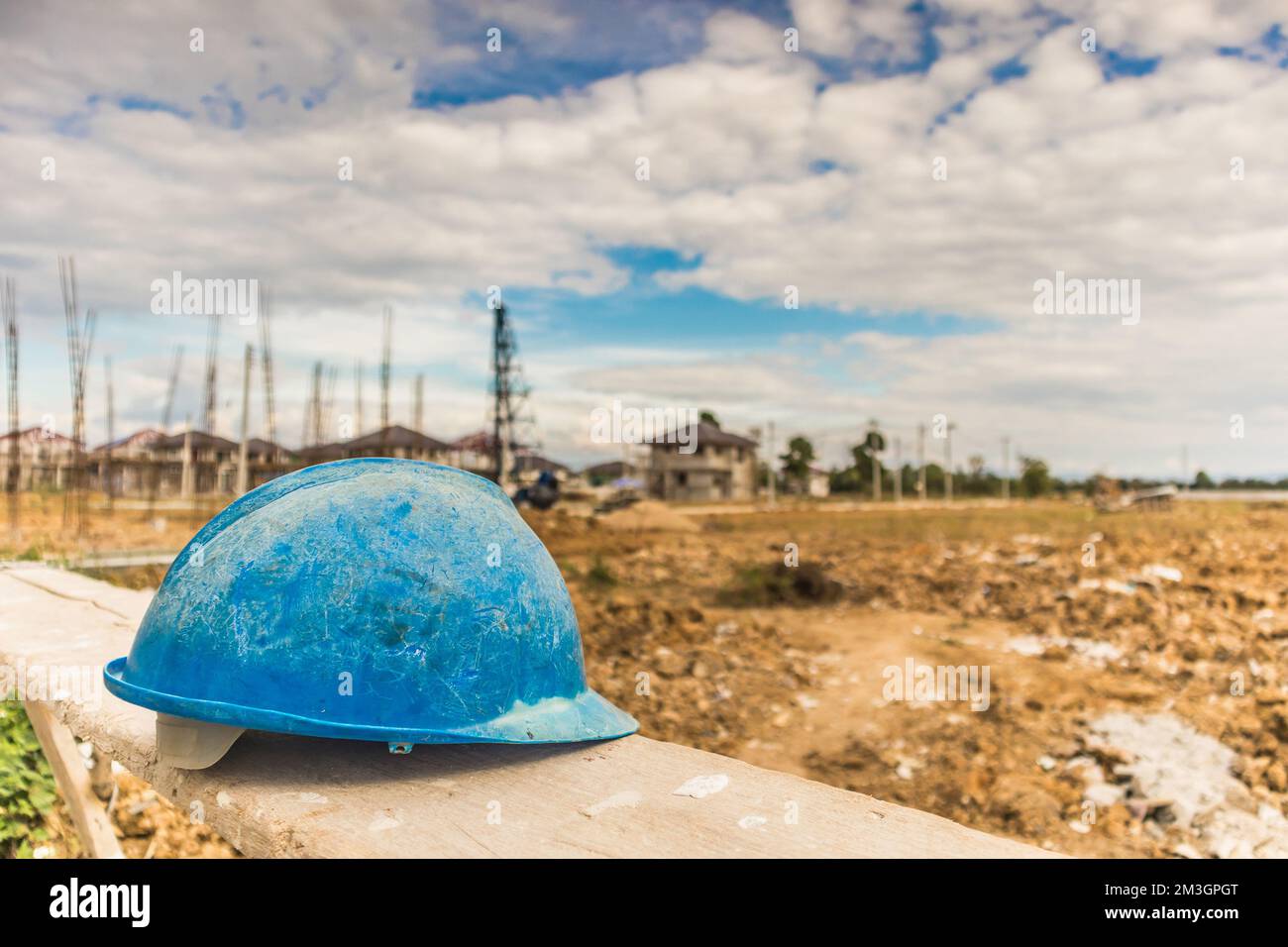 Blue hard hat on house building construction site Stock Photo - Alamy