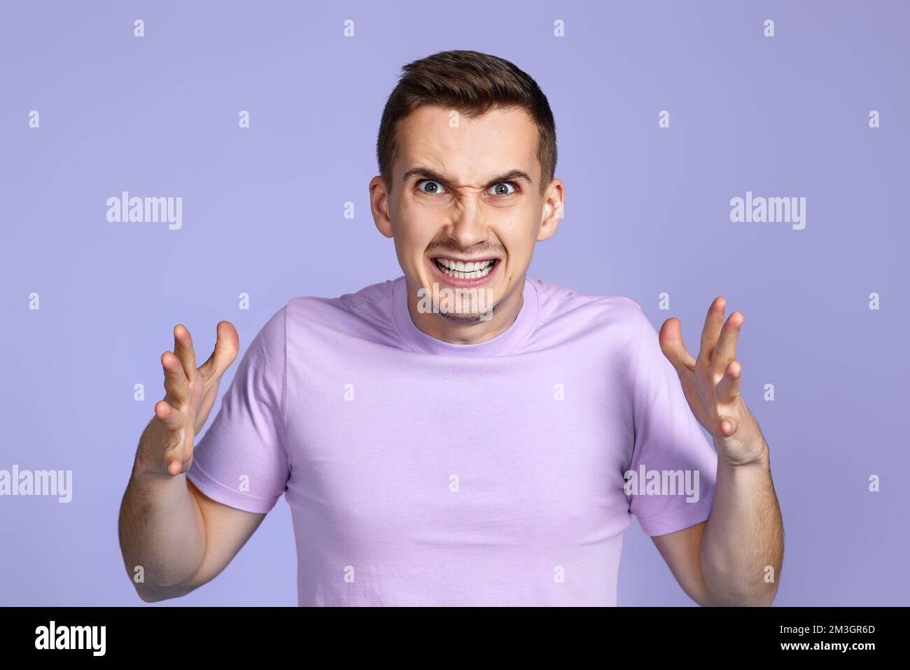 annoyed angry man on pastel purple studio background Stock Photo - Alamy