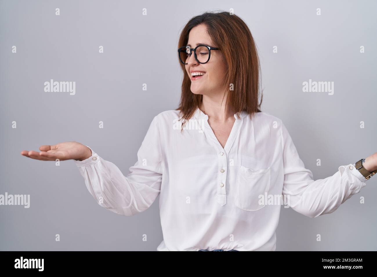 Brunette woman standing over white isolated background smiling showing ...
