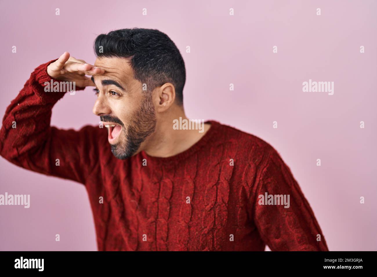 Young hispanic man with beard wearing casual sweater over pink ...