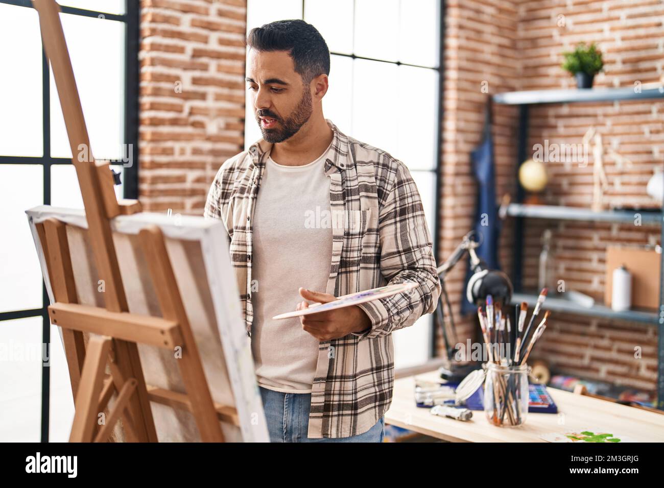 Young hispanic man drawing at art studio Stock Photo - Alamy