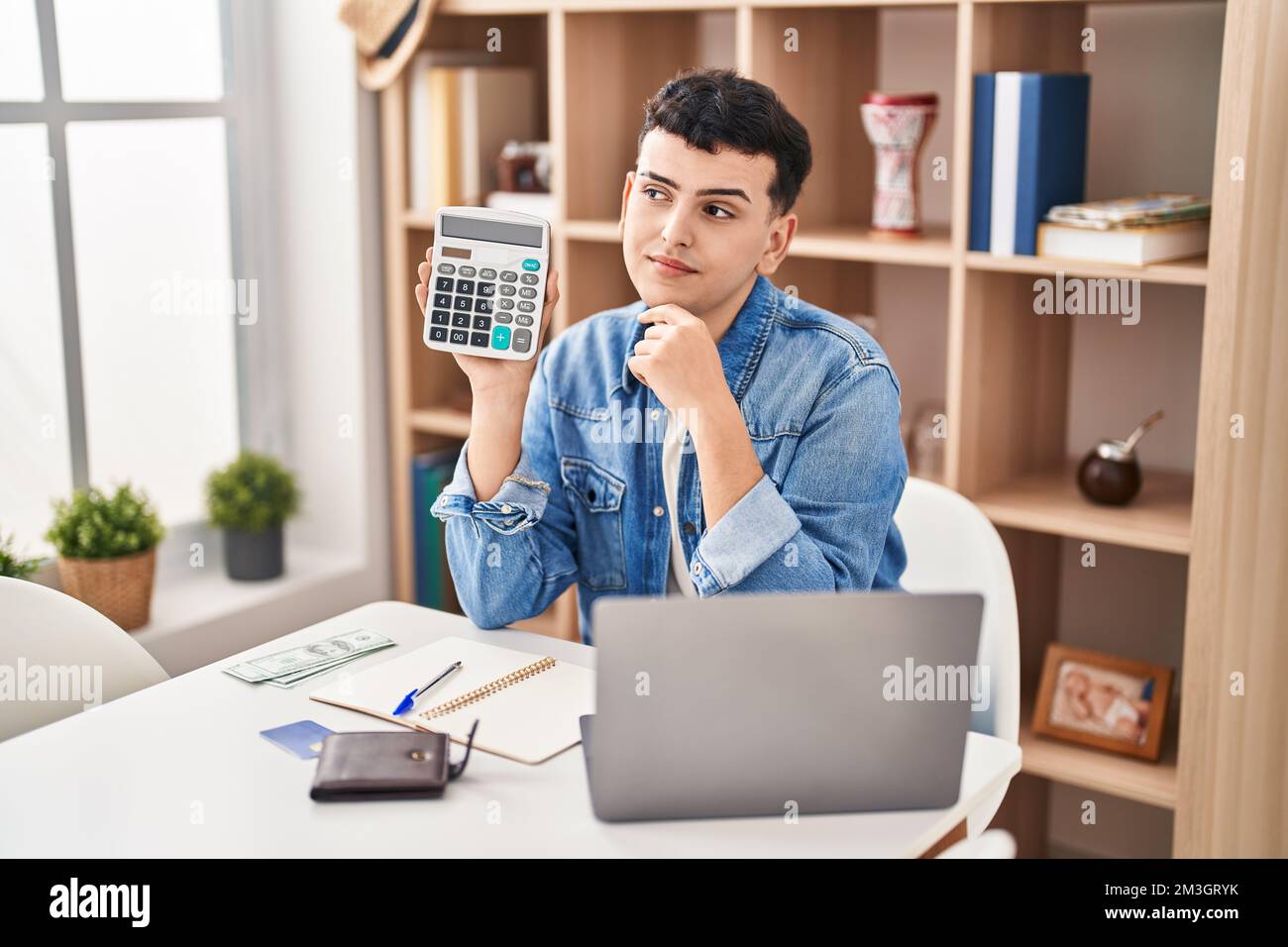 Non binary person calculating money savings serious face thinking about ...