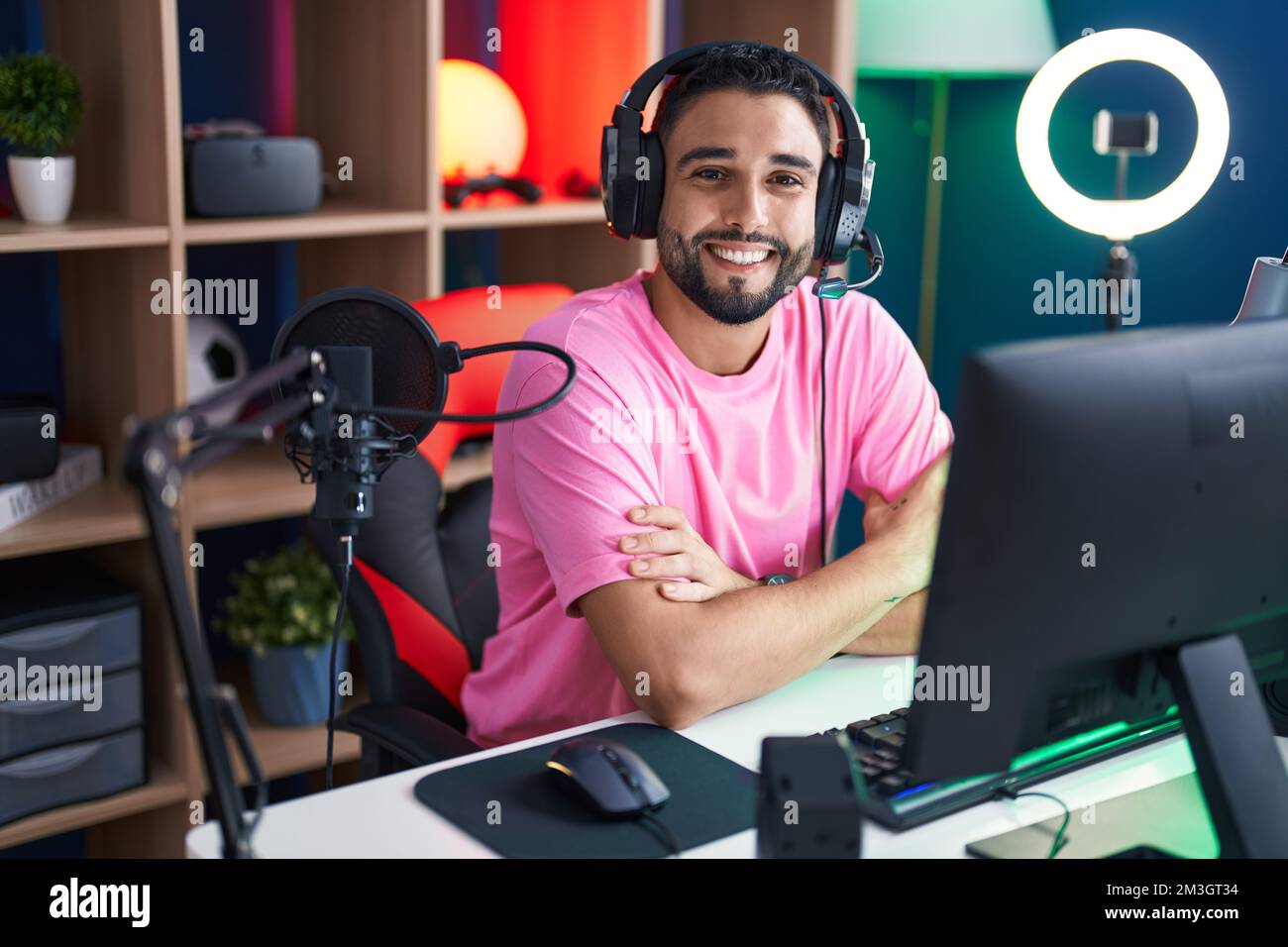 Young arab man streamer smiling confident sitting with arms crossed ...