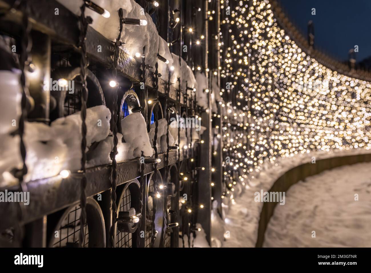 Ornamental, metal fence decorated with led illumination. Snow covering ...