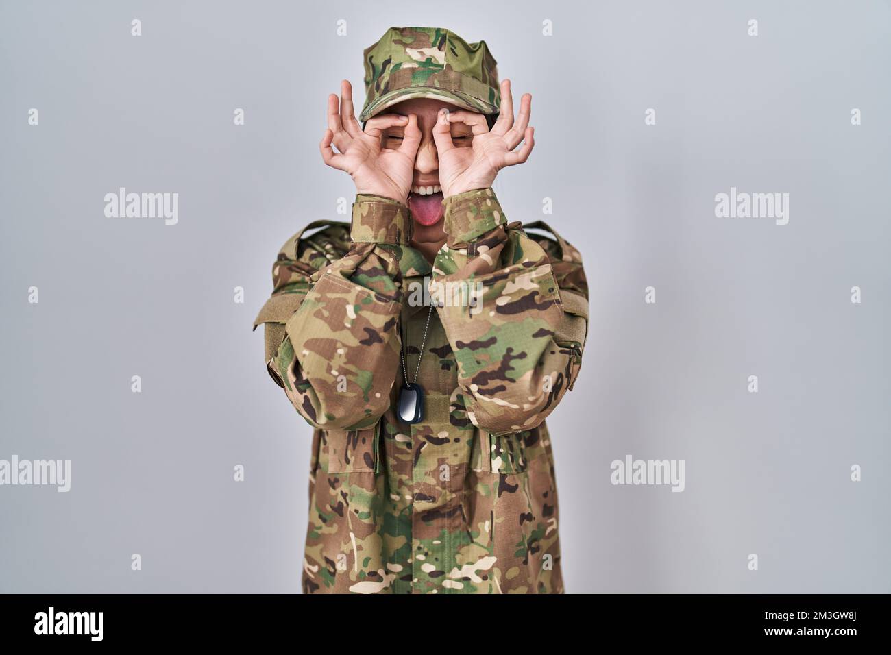 Young south asian woman wearing camouflage army uniform doing ok ...