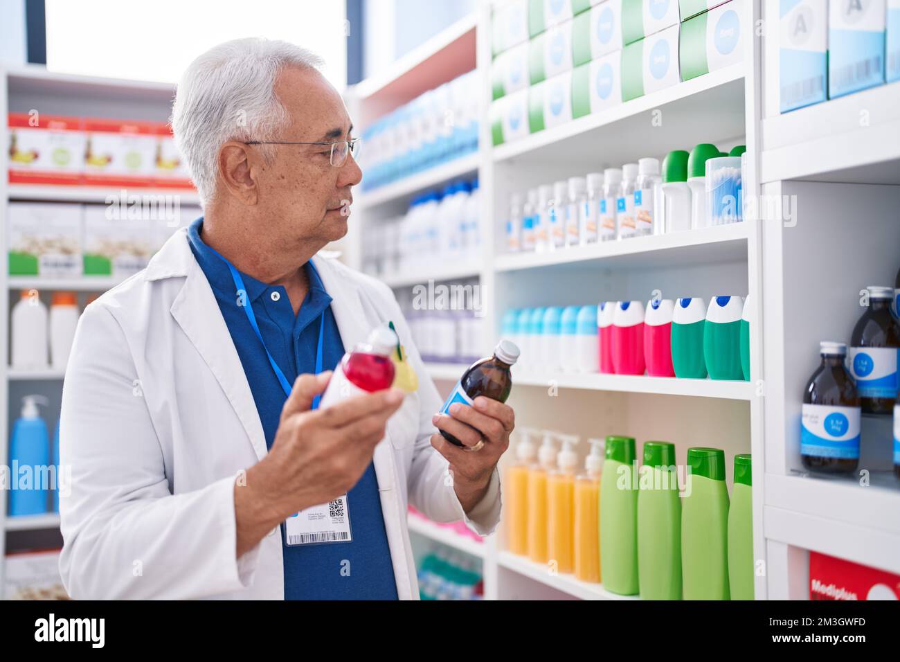 Middle age grey-haired man pharmacist smiling confident holding ...