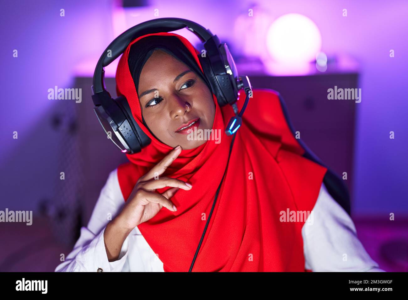 Young beautiful woman streamer sitting on table with serious expression ...