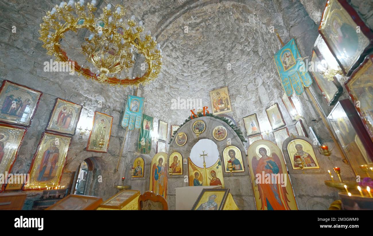 Church in stone cave. Action. Interior of cave church with icons ...