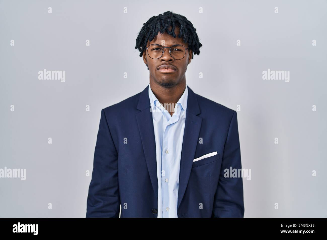 Young african man with dreadlocks wearing business jacket over white ...