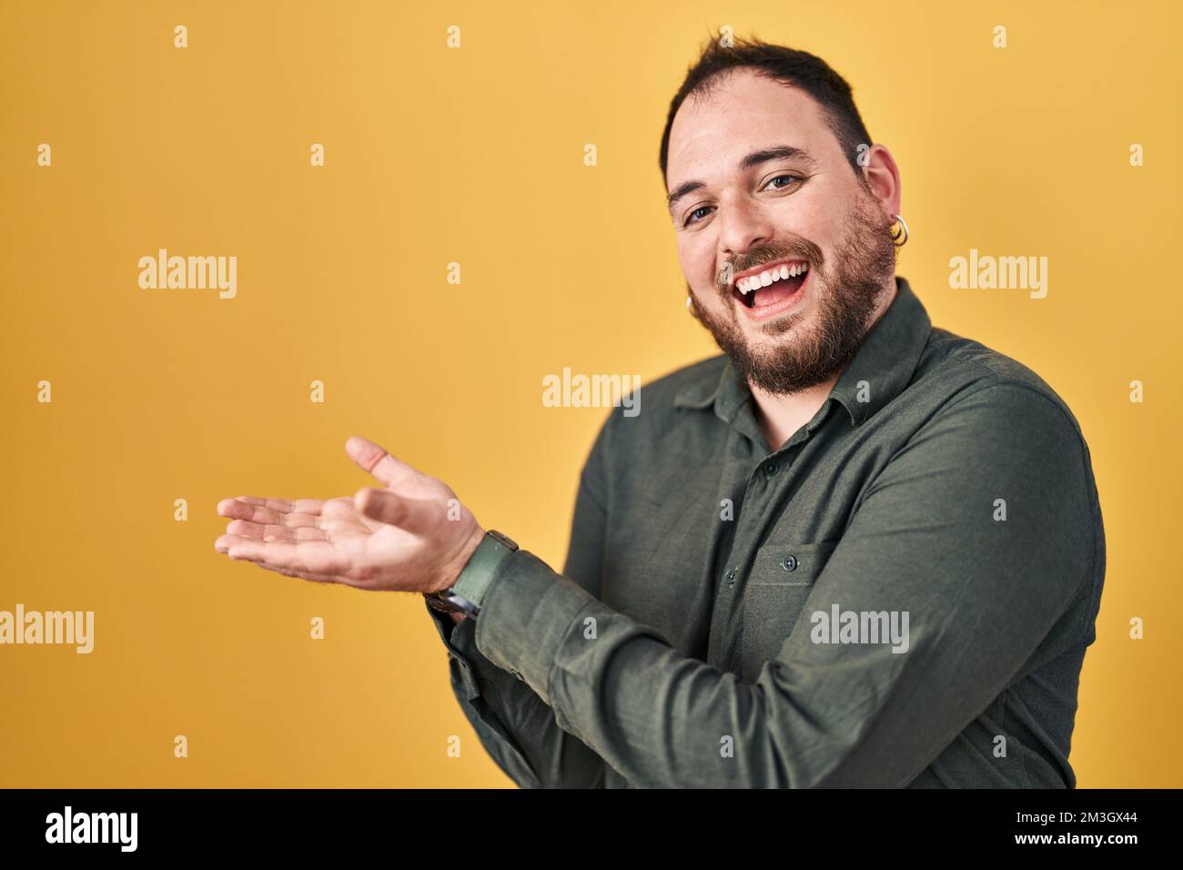 Plus size hispanic man with beard standing over yellow background ...