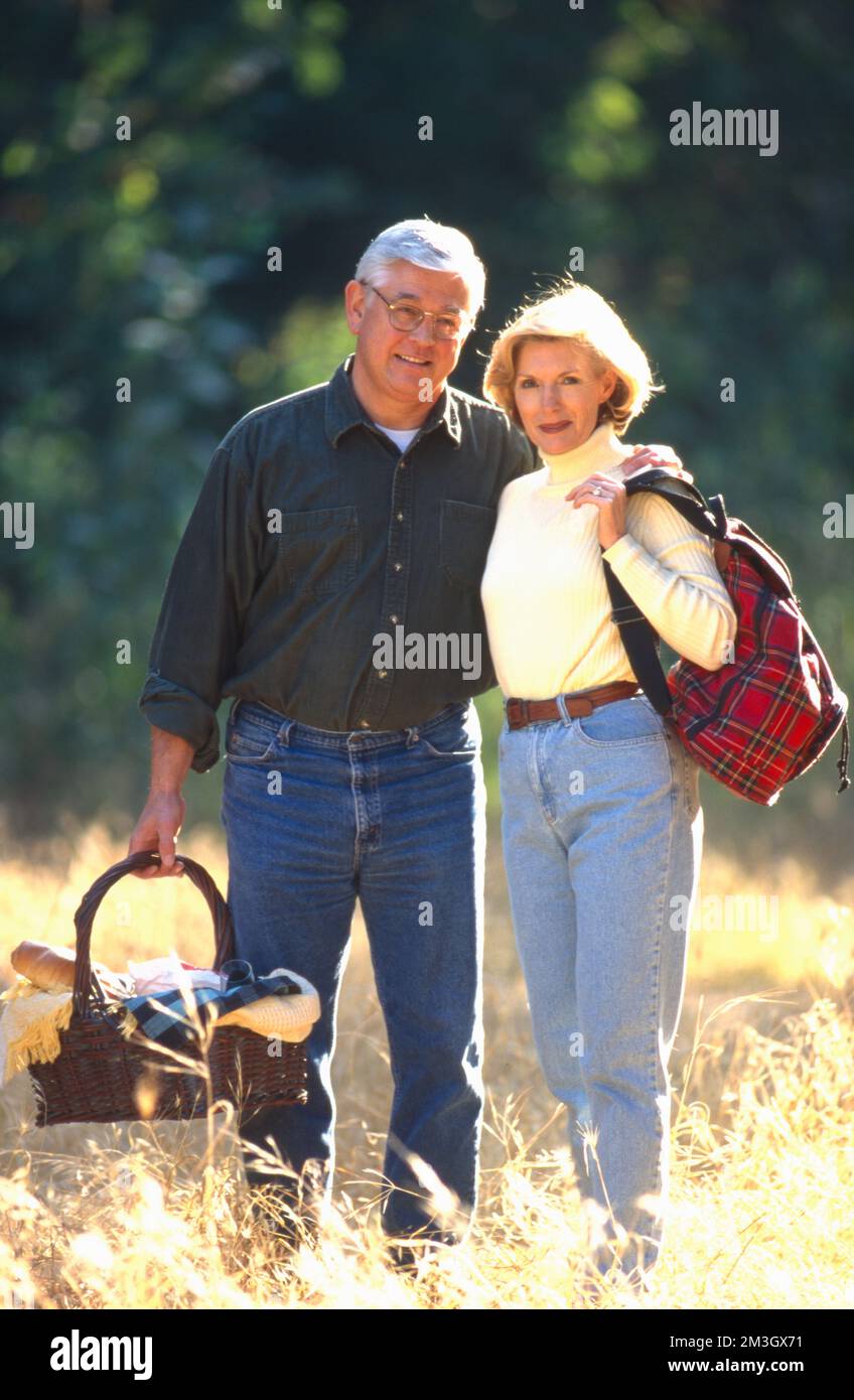Older couple pausing for a portrait while heading out for picnic Stock ...
