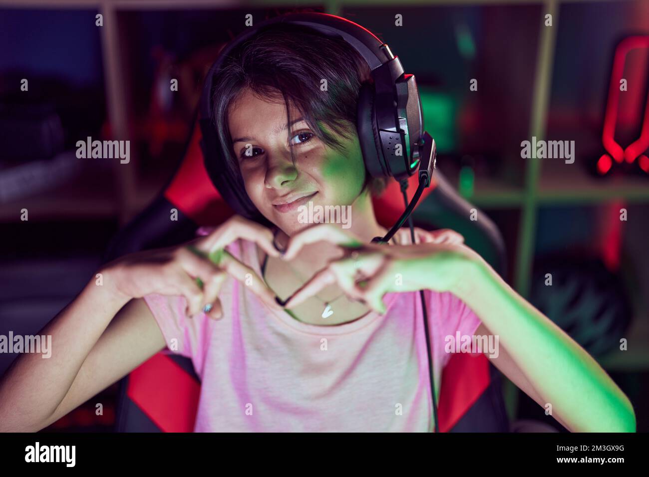 Adorable hispanic girl streamer smiling confident doing heart symbol ...