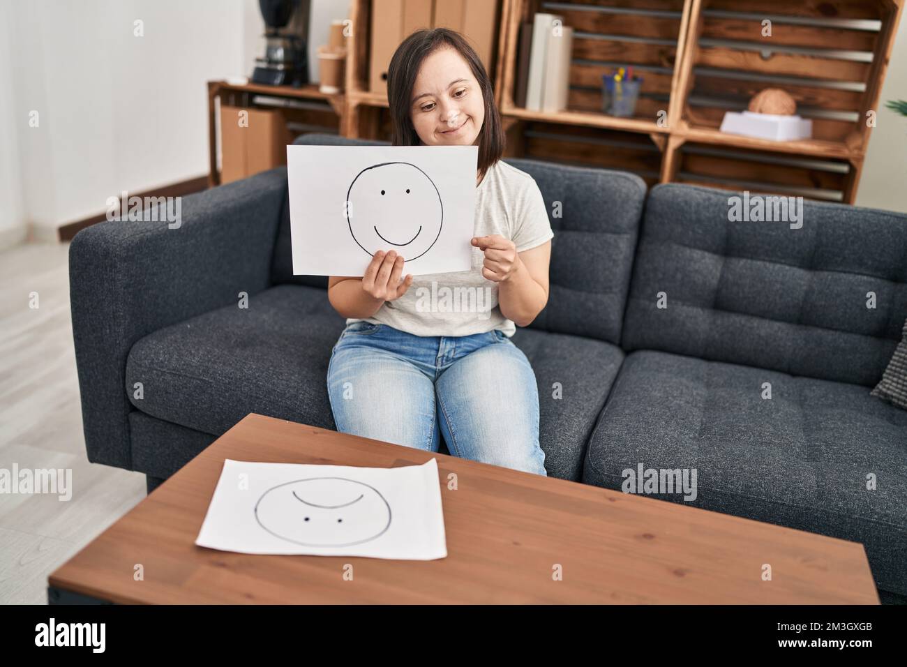 Down syndrome woman patient having psychology session pointing to happy ...