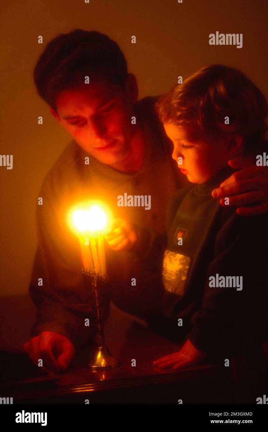 Dad and son lighting the menorah Stock Photo - Alamy