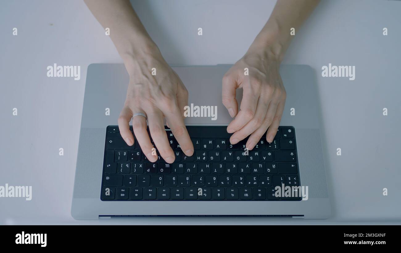 Hands typing on keyboard. Action. Top view of hands typing on laptop ...