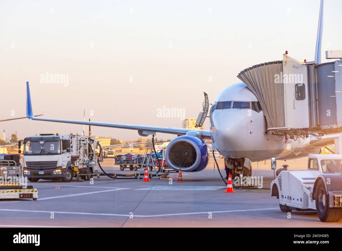 Passenger plane parked at the airport. Refueling operation in action ...