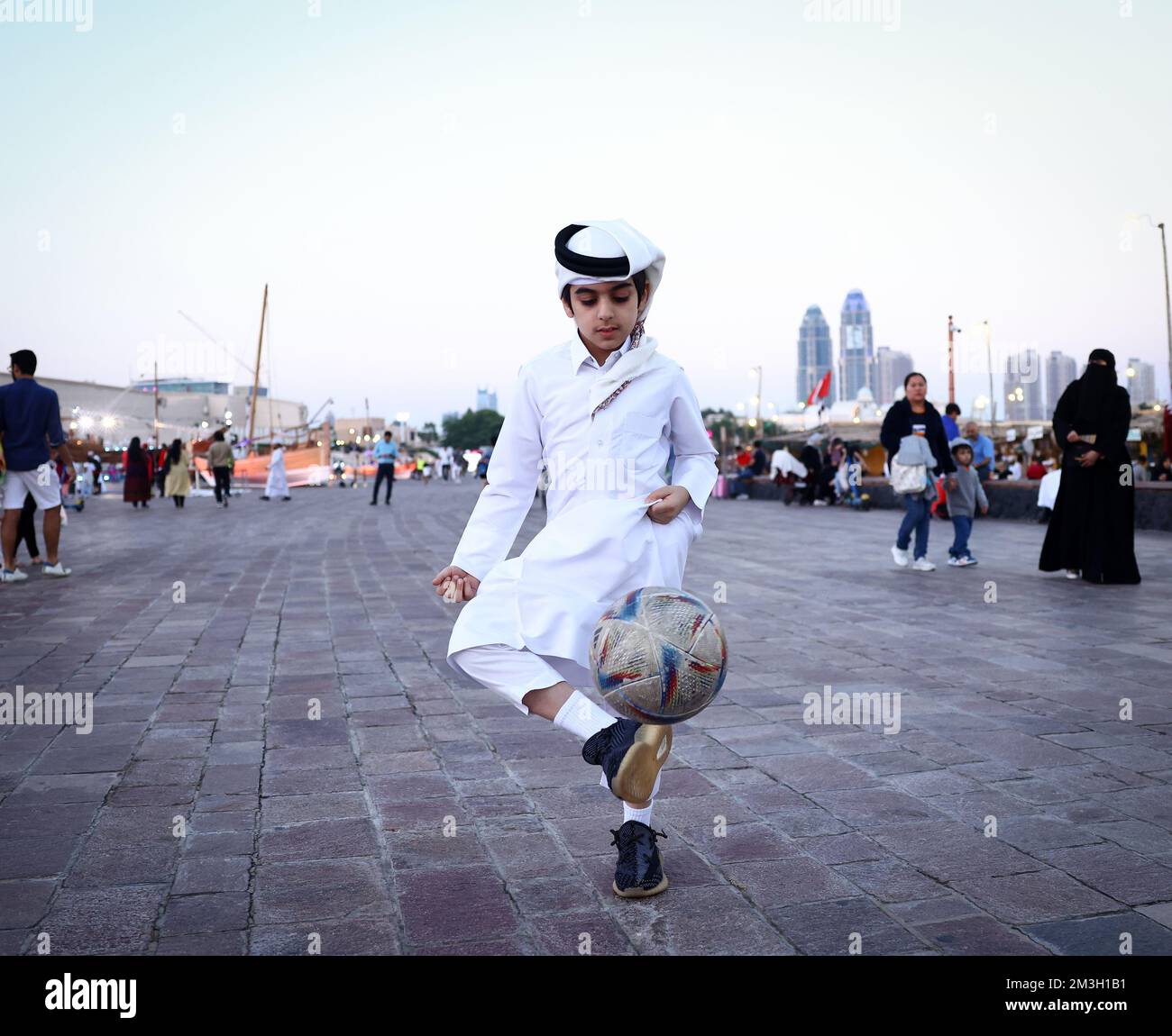 Doha, Qatar, 15th November 2022. A young boy in traditional dress poses with a football during ...