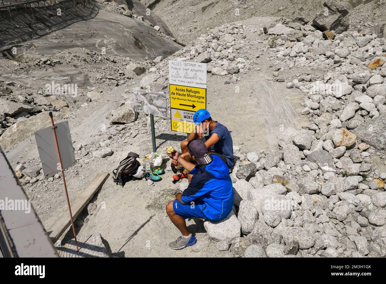 Two men take a break sitting outside the Ice Cave at the Mer de Glace ...