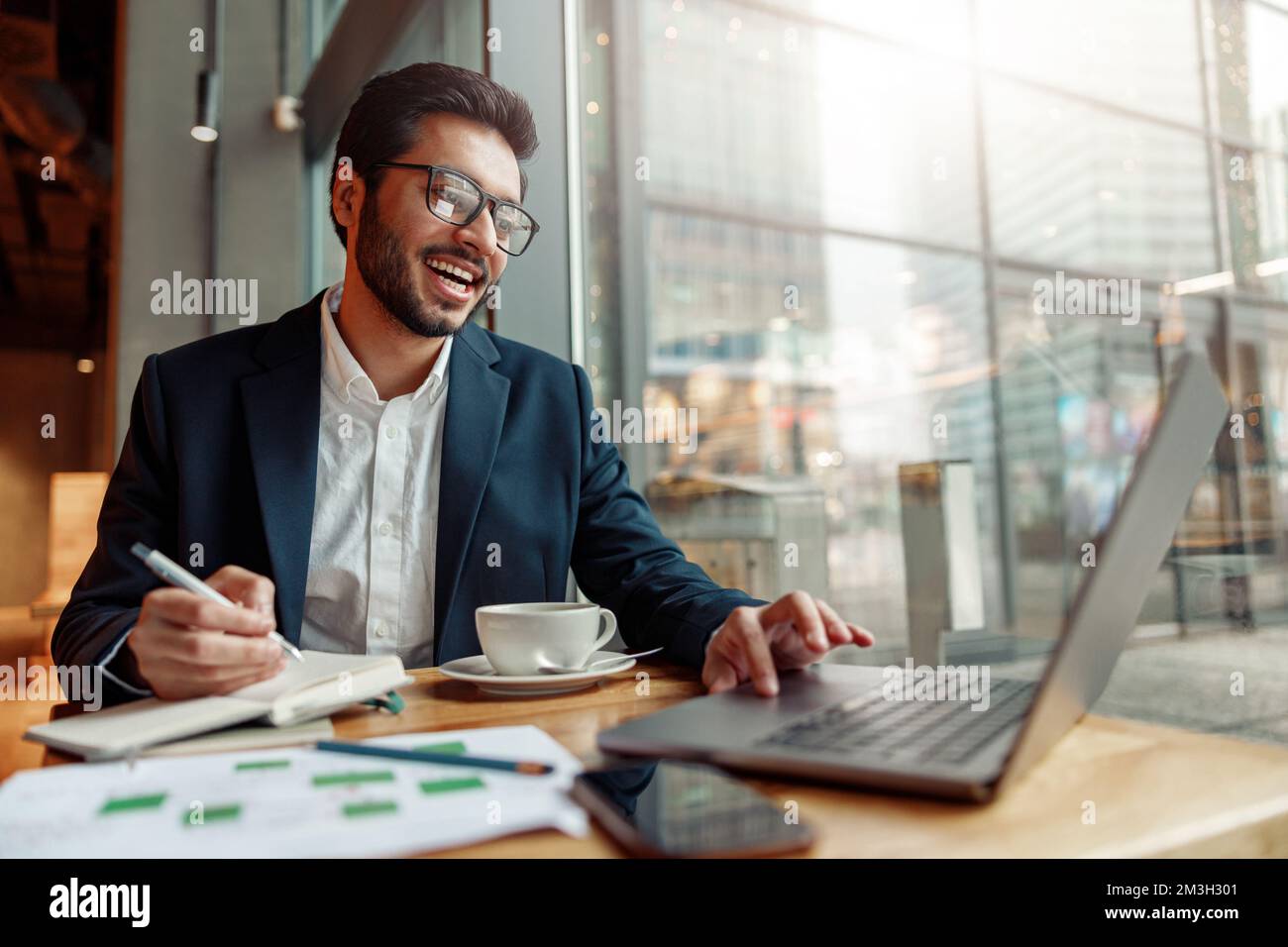 Indian businessman is making notes in notepad during working day in ...