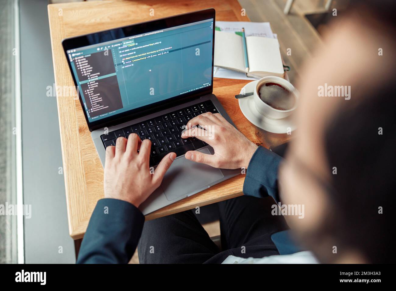 Back view of developer programmer freelancer working on project in cafe ...