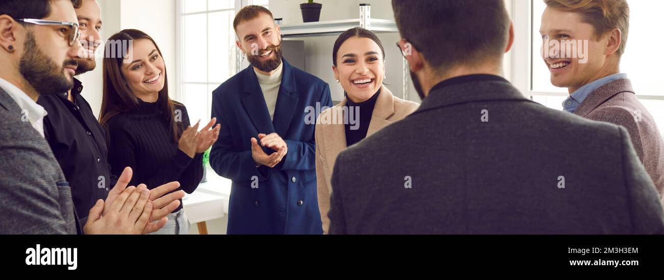 Happy business team applauding and congratulating their colleague on ...