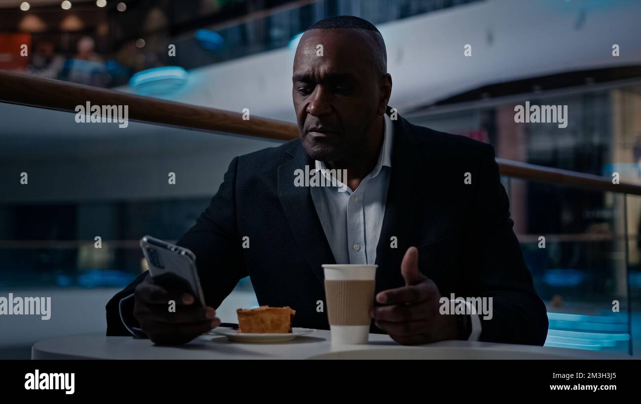 Ethnic African American middle-aged businessman in cafe table mature ...