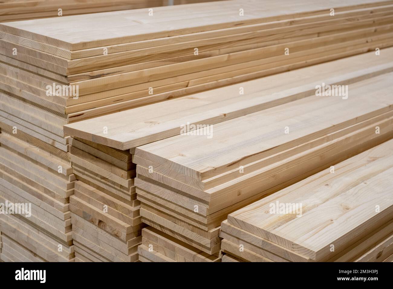 Stacks of pine wood planks in a store or on building site. Natural ...