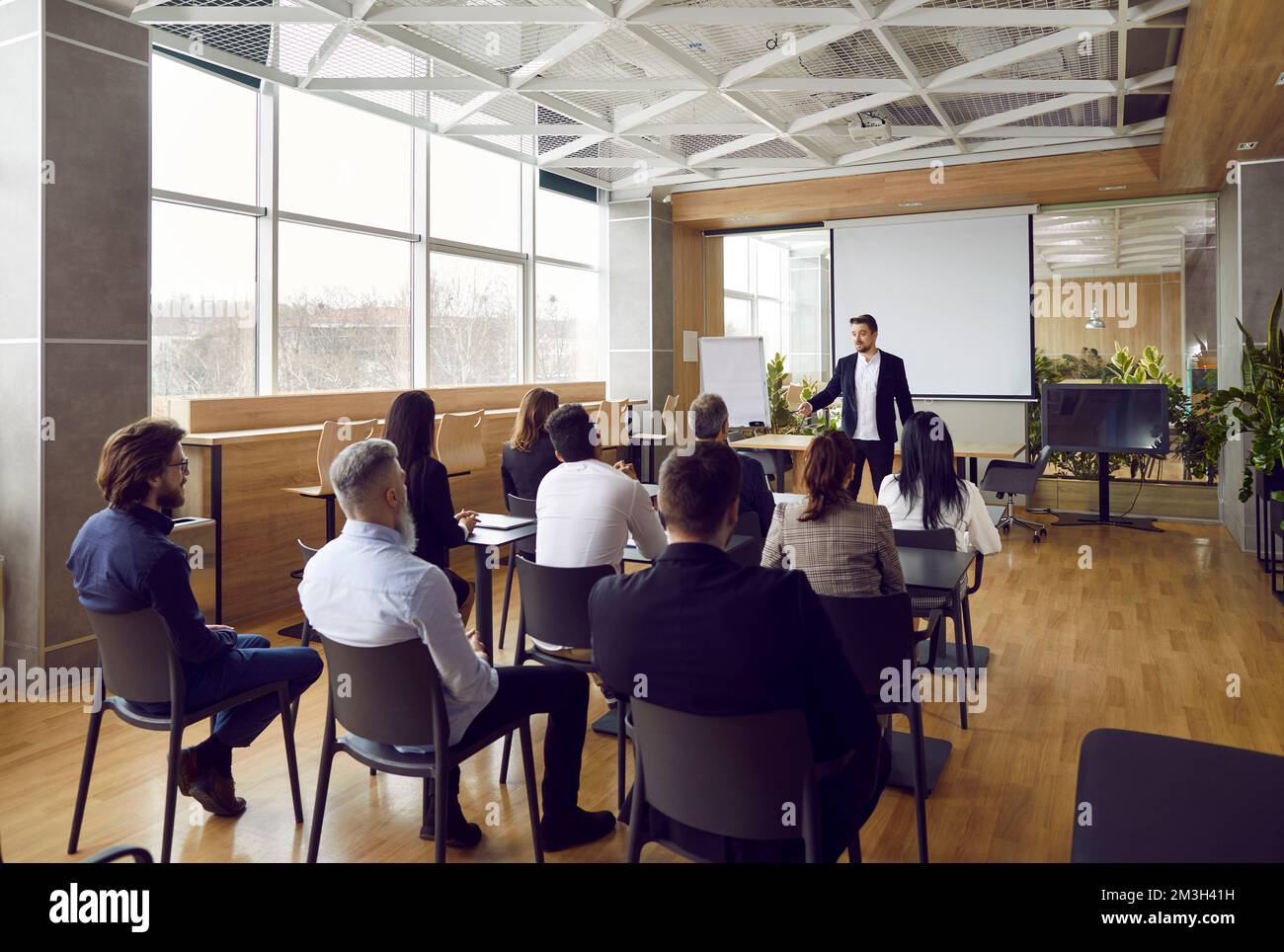 Team of people sitting at desks in office and having class with ...