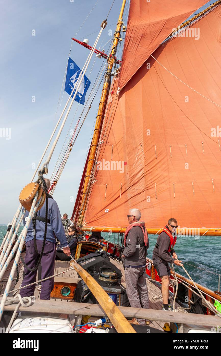 Crew working aboard the traditional gaff cutter "Jolie Brise", running ...