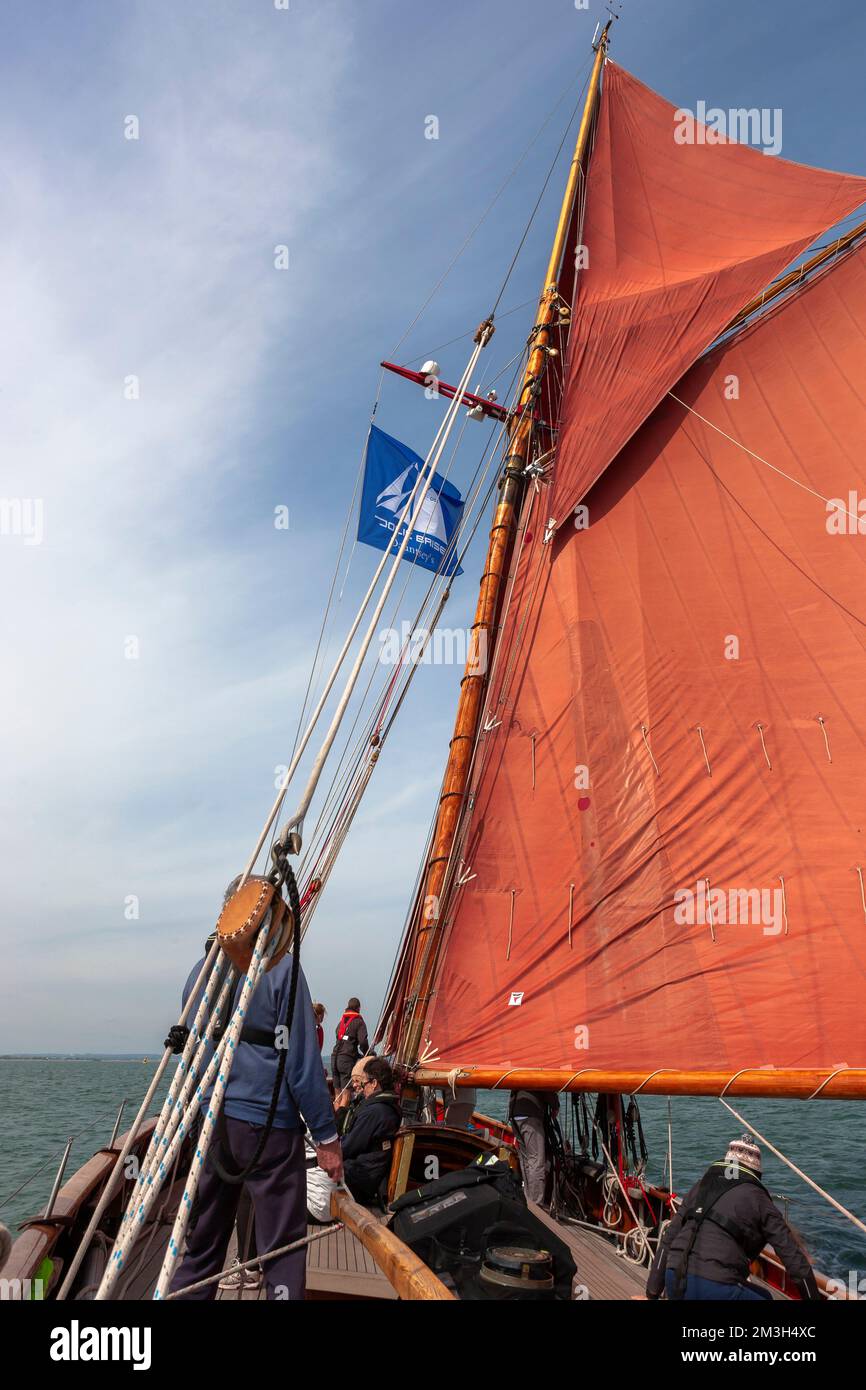Crew working aboard the traditional gaff cutter "Jolie Brise", running ...