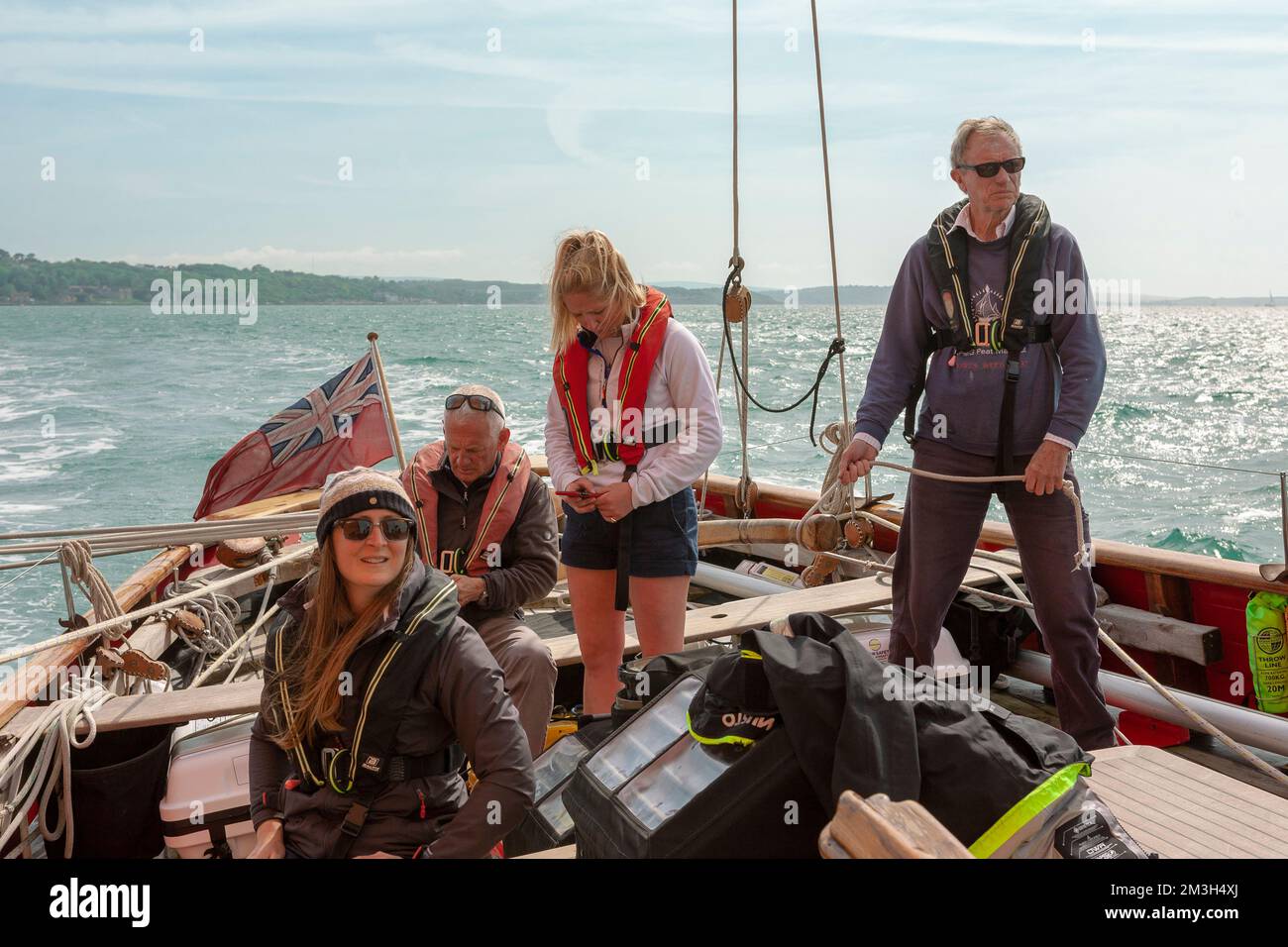 Crew working aboard the traditional gaff cutter "Jolie Brise", running ...