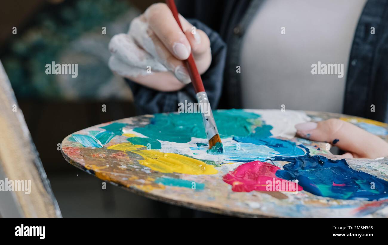 Closeup woman female hand artist painter paints draws creating new art ...