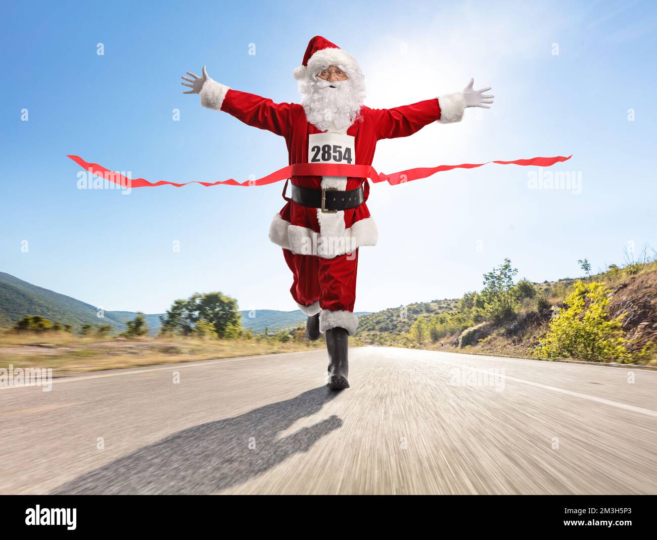 Happy Santa Claus running a race on an asphalt road at the finish line Stock Photo - Alamy