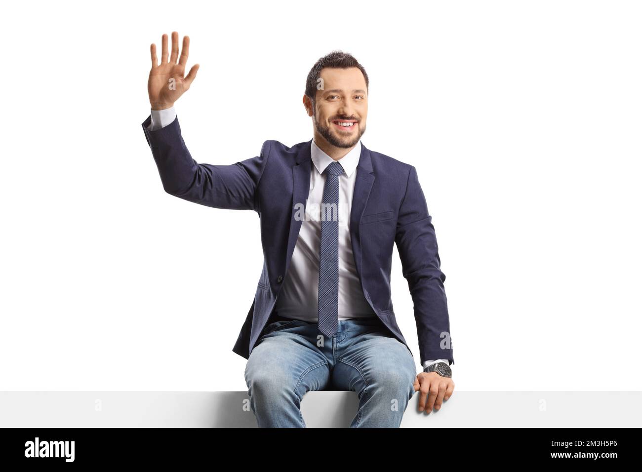 Man sitting on a blank panel and waving isolated on white background ...