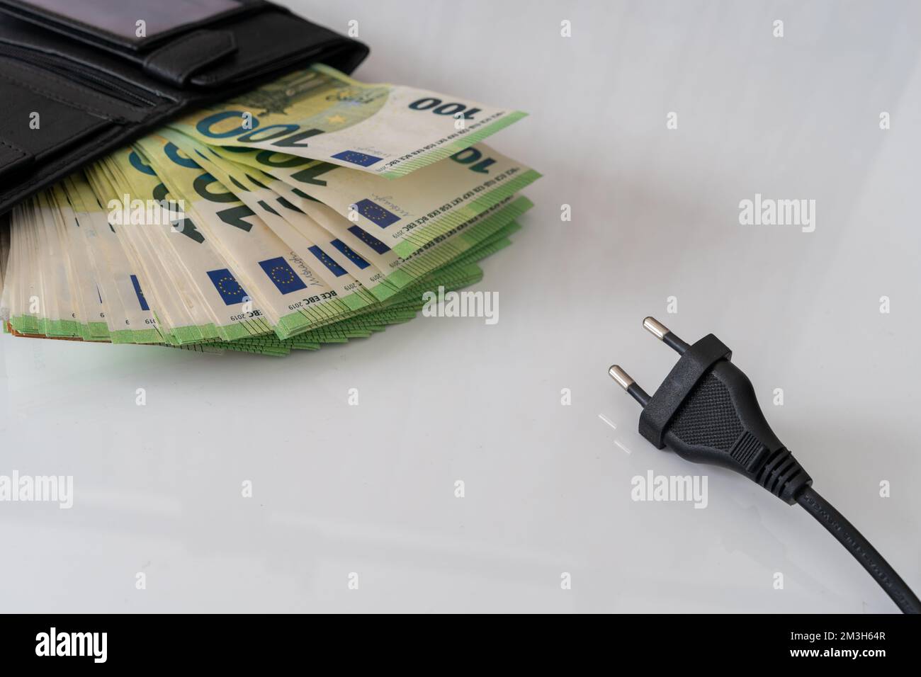 The euro banknotes in a wallet and a cable plug Stock Photo - Alamy
