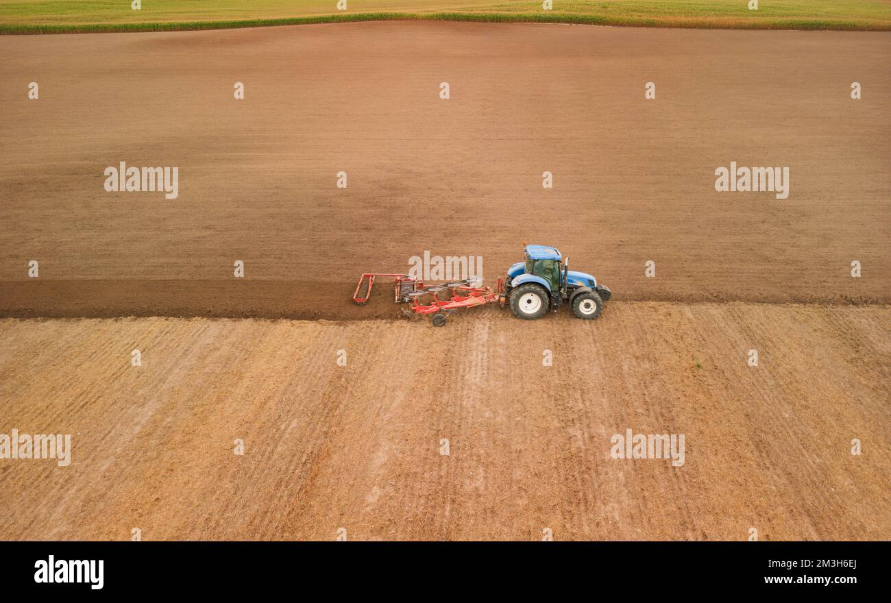 A tractor with a plow plowing a field, field cultivation, view from the ...