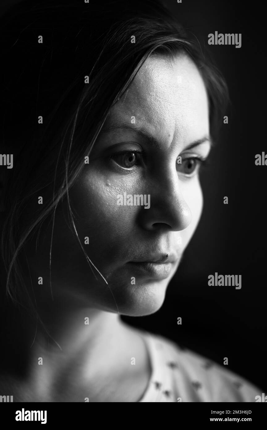 Monochrome portrait of a woman with light from the window, portrait of ...