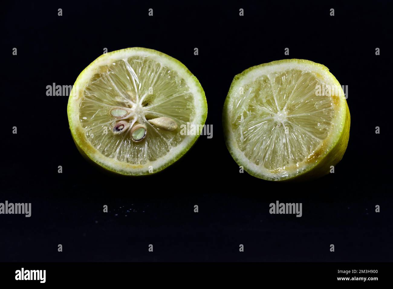 A cut lemon isolated on black background Stock Photo - Alamy