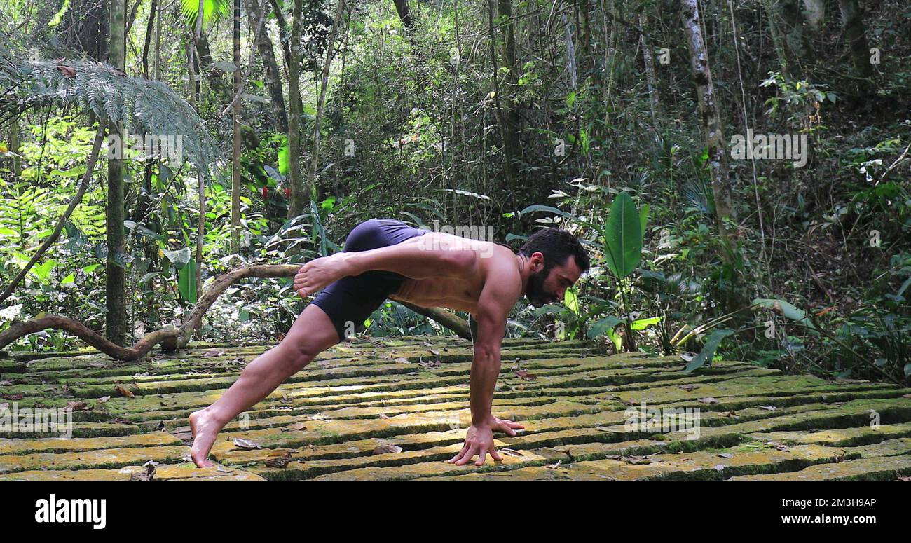 Fit man training Yoga in the middle of tropical jungle Stock Photo - Alamy
