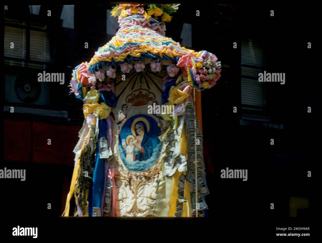 Money pinned around processional image of Madonna and Child , Religious ...