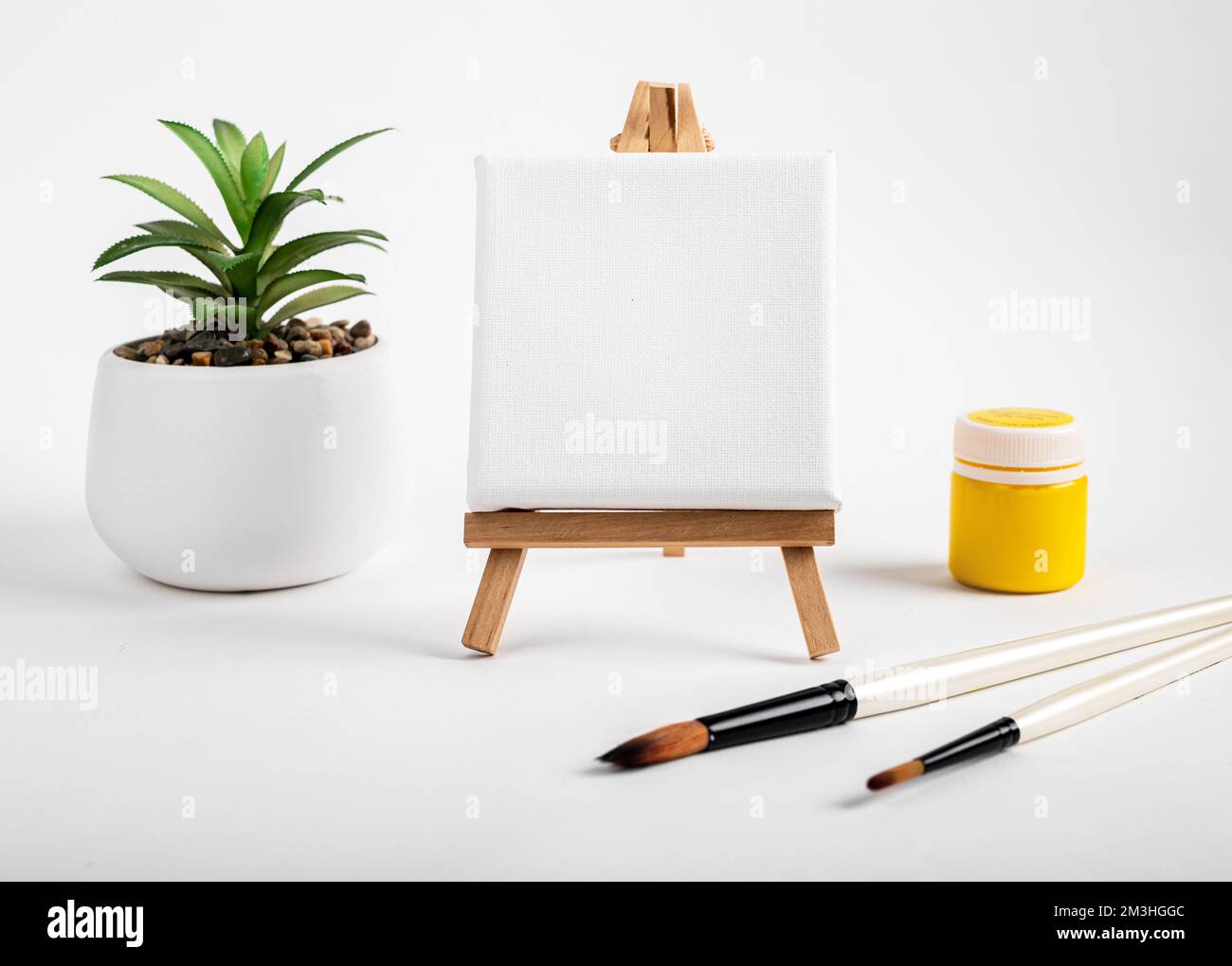 Clean blank canvas mockup for painting, drawing on easel, paint brushes ...