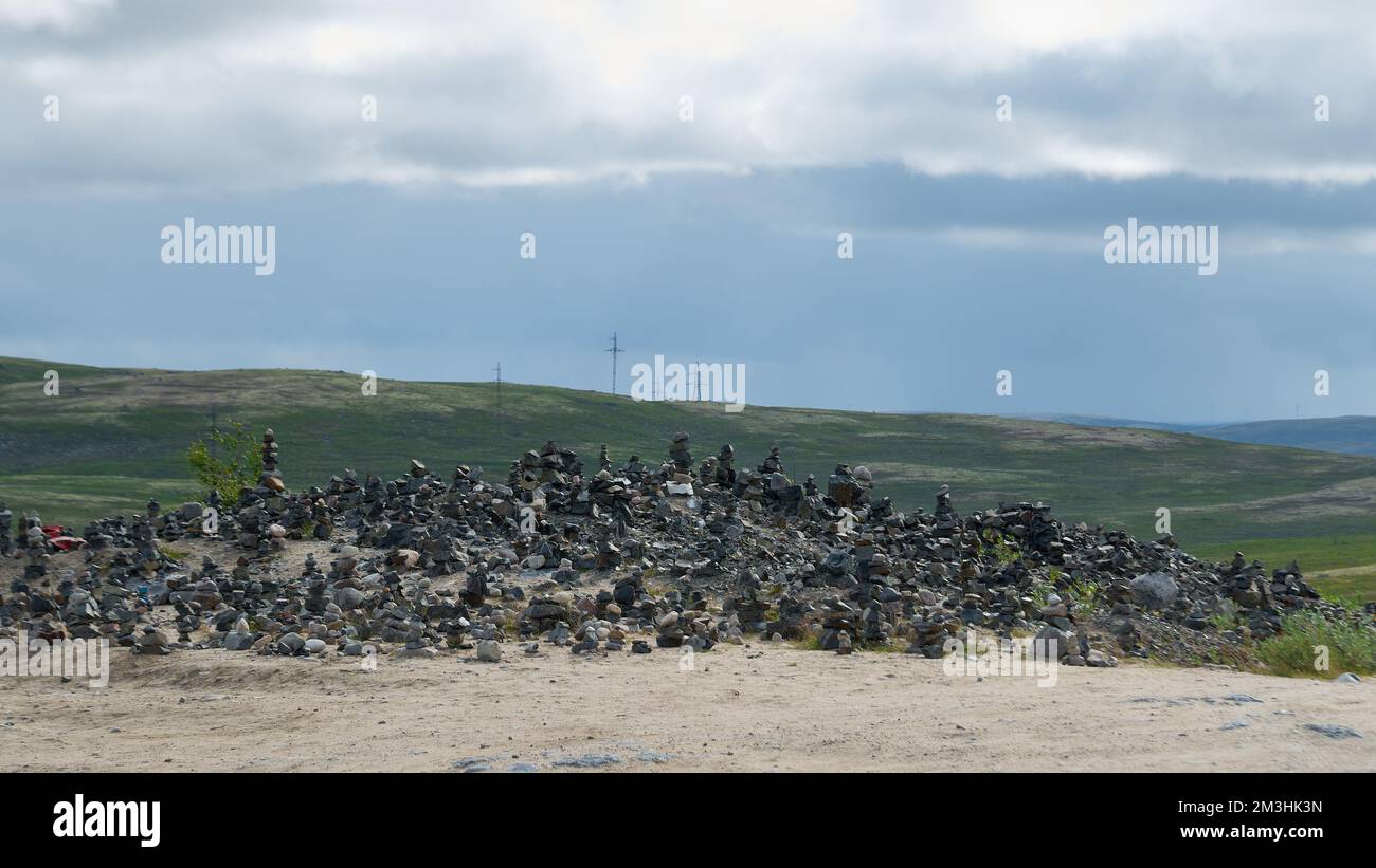A large number of zen pyramids made of stones on the side of a mountain ...