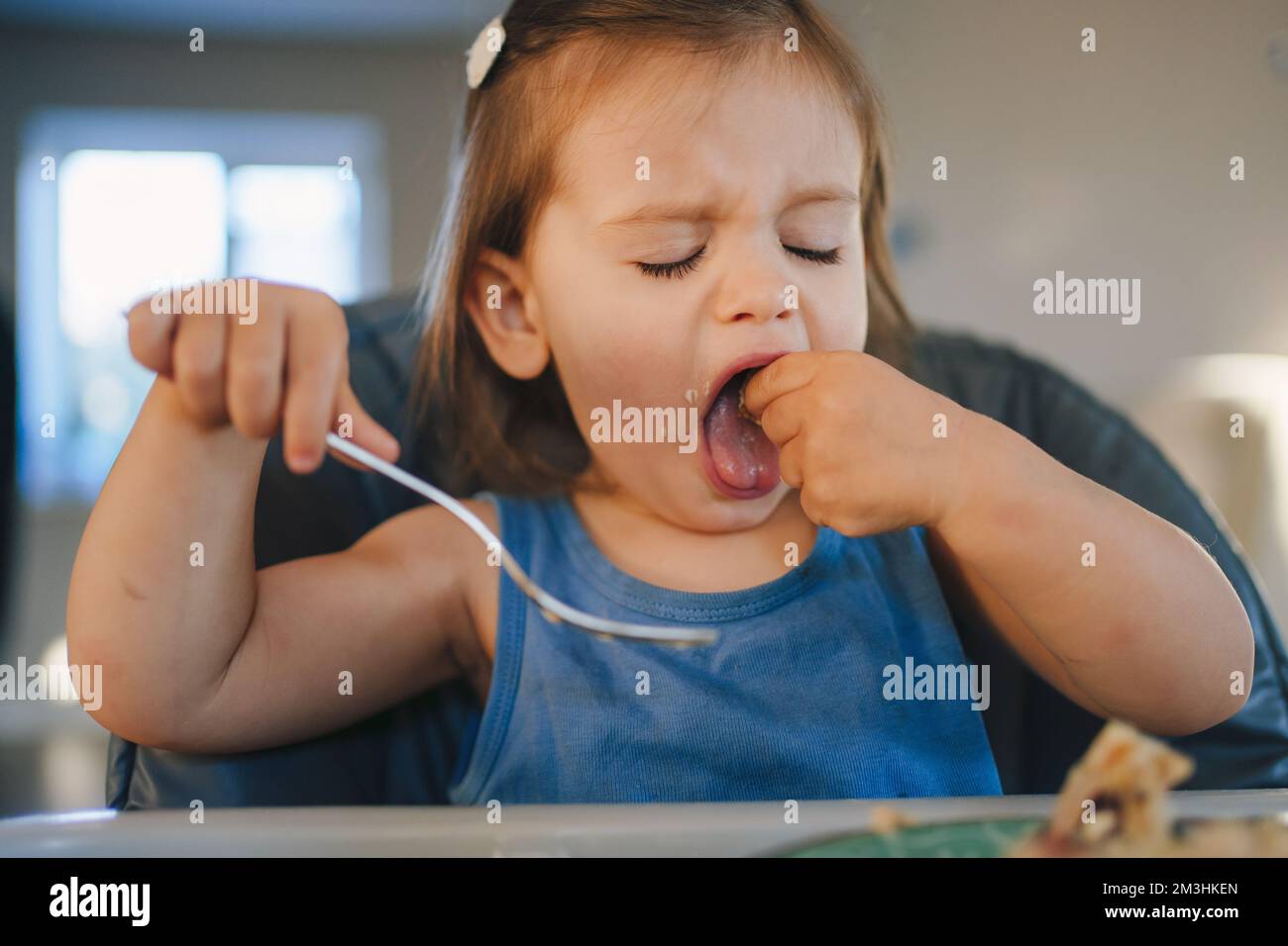Baby girl eating itself, taking whole foods to the mouth. Baby eat by ...