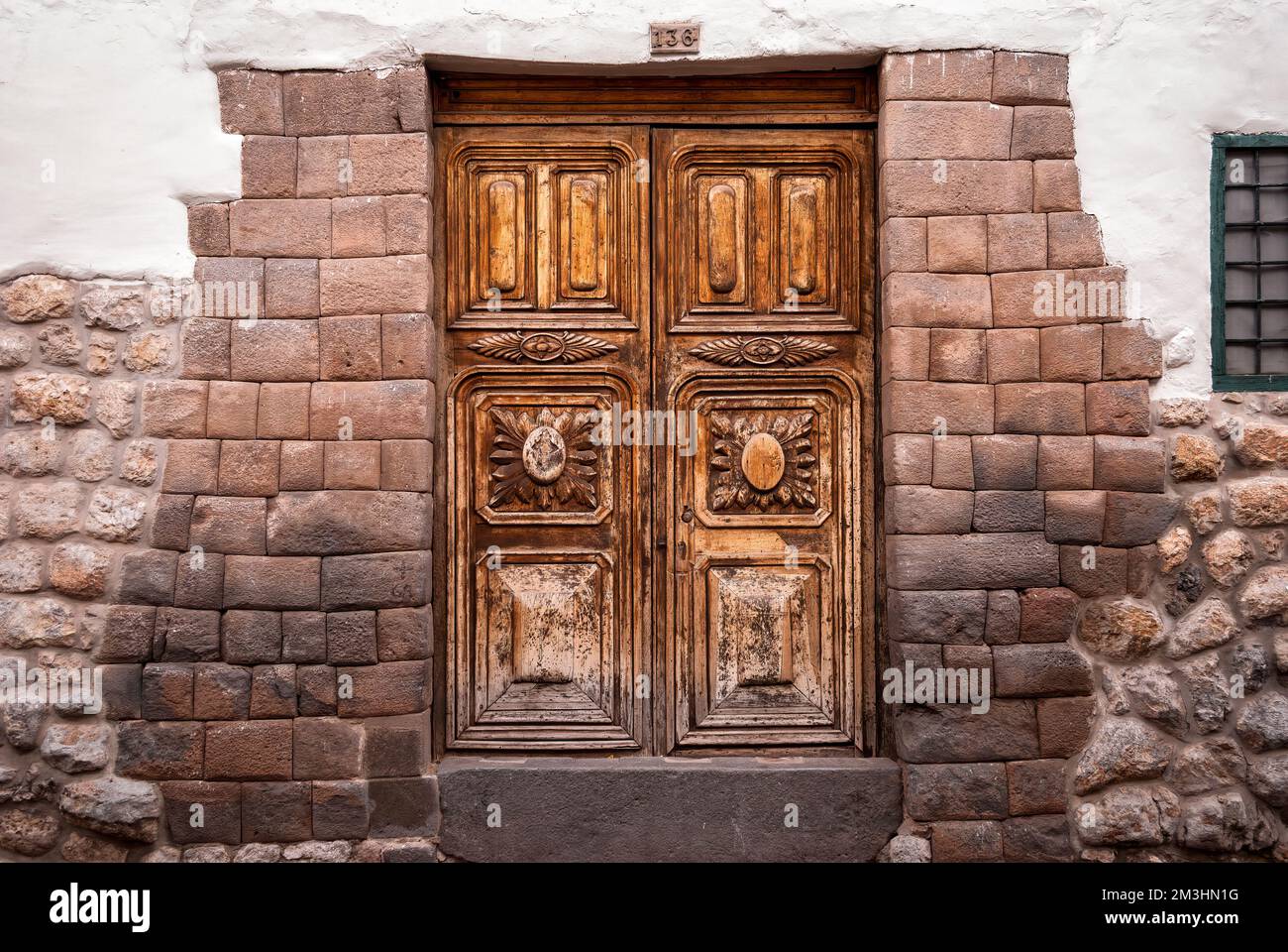Old wooden door of a colonial building on incan stone wall, Cusco, Peru ...