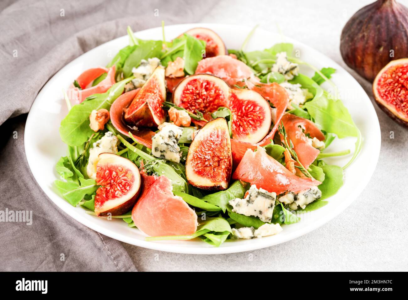 Healthy salad with fresh fig, blue cheese, prosciutto, arugula and ...