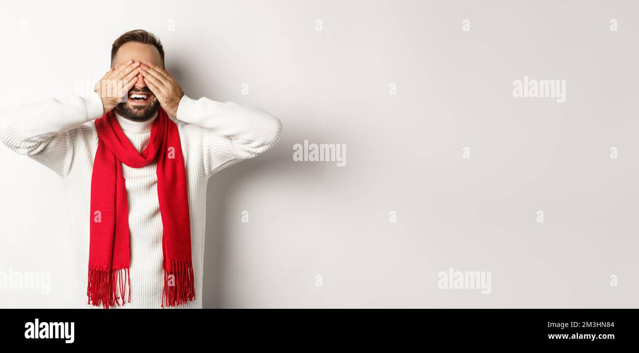 Winter holidays and shopping concept. Happy boyfriend waiting for ...