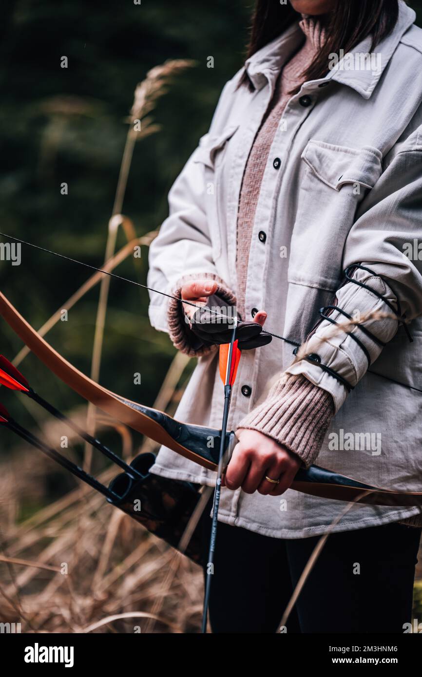 A closeup view of a female holding a bow with arrow Stock Photo - Alamy