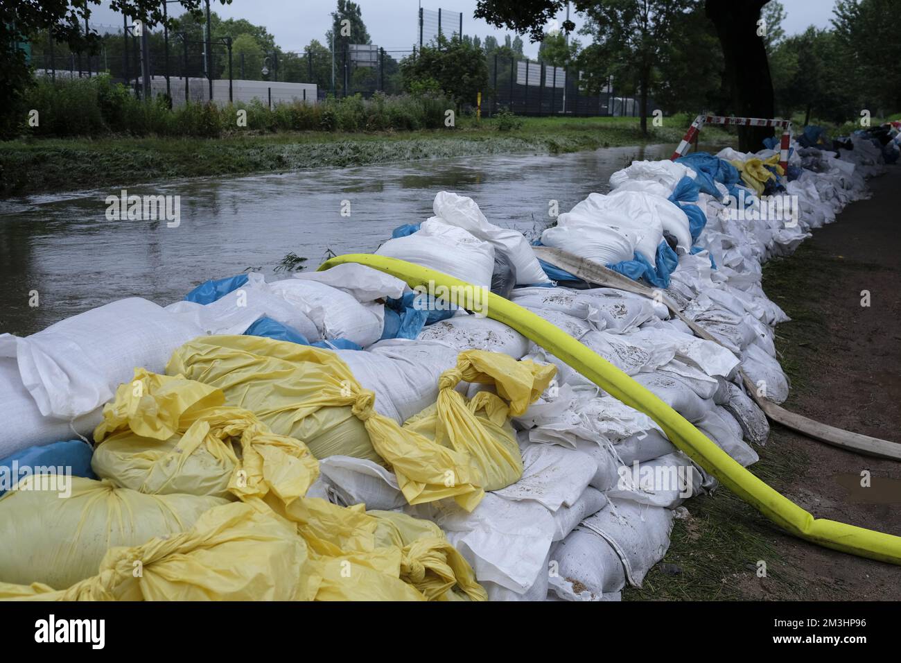 A line of sand bags and hoses to pump water out of flooded basements in ...